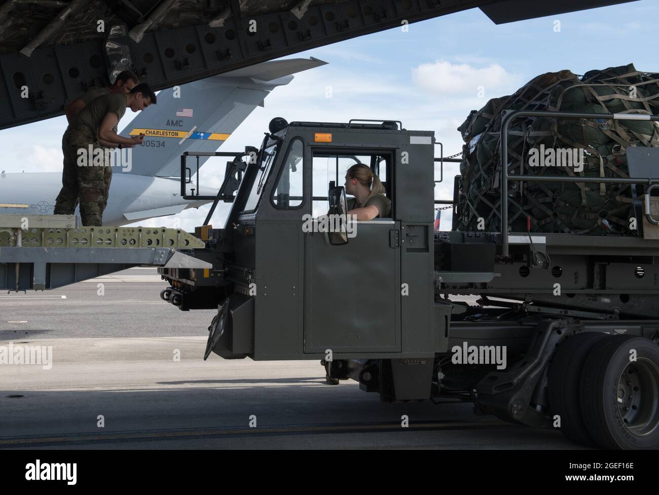 A U.S. Air Force loadmaster directs cargo to be loaded on to a C-17 ...