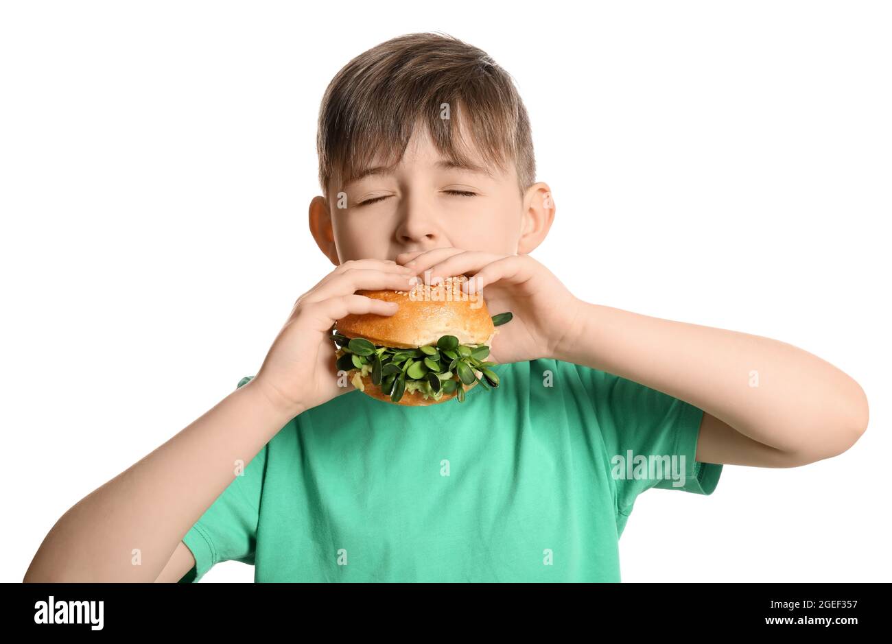 Little boy eating tasty vegan burger on white background Stock Photo ...