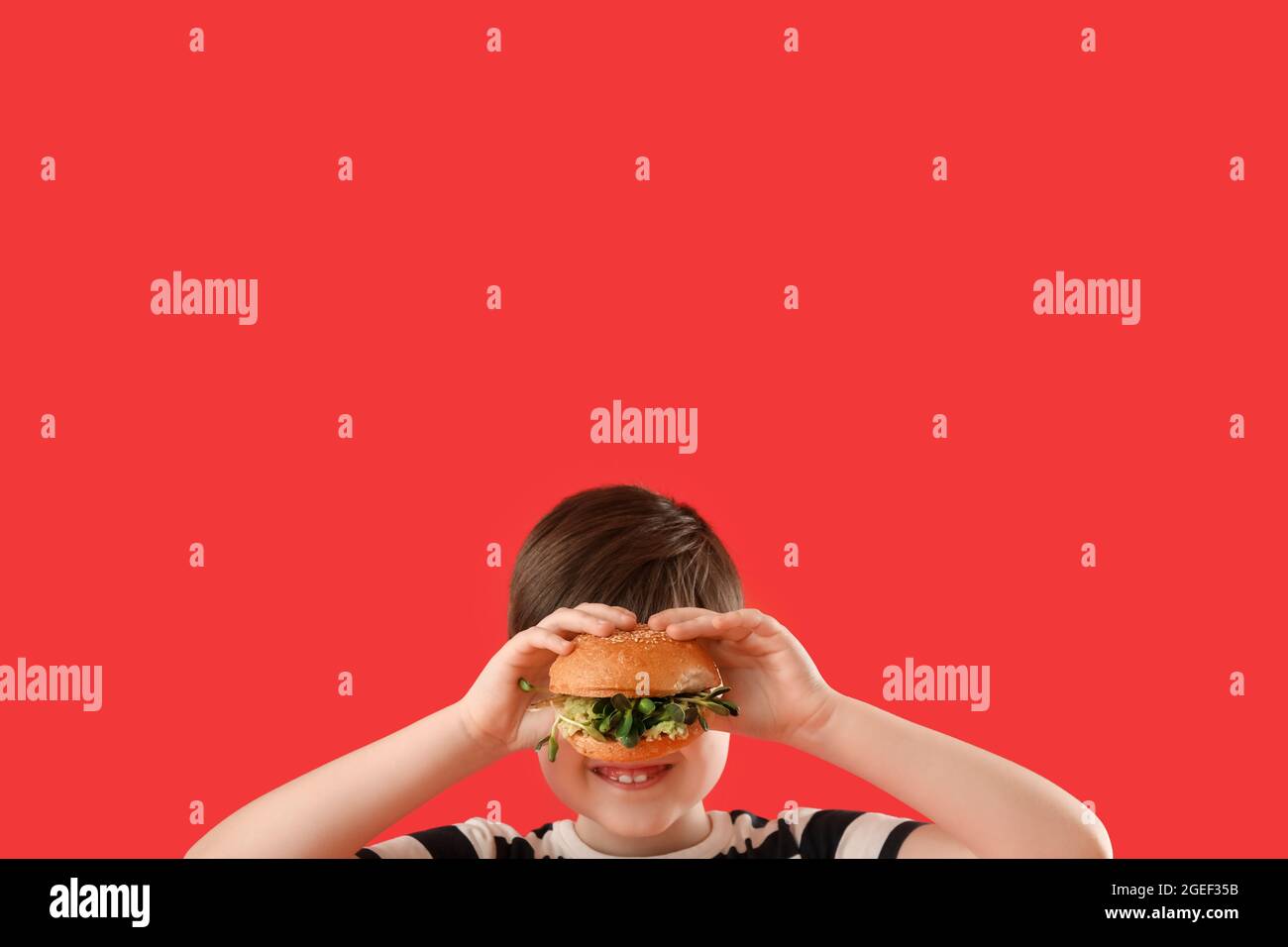 Little boy with tasty vegan burger on color background Stock Photo - Alamy