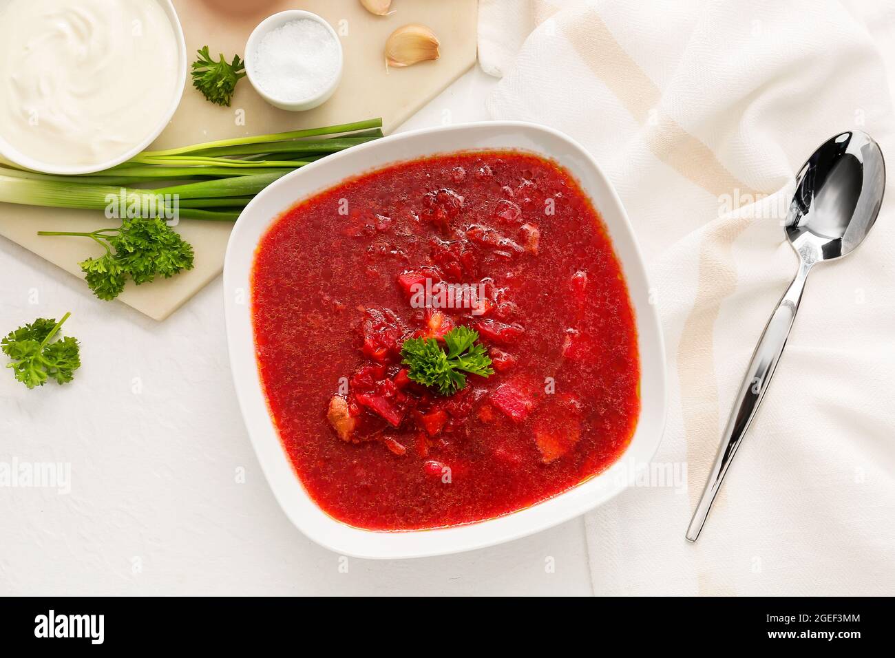Bowl with tasty borscht, sour cream and green onion on light background ...
