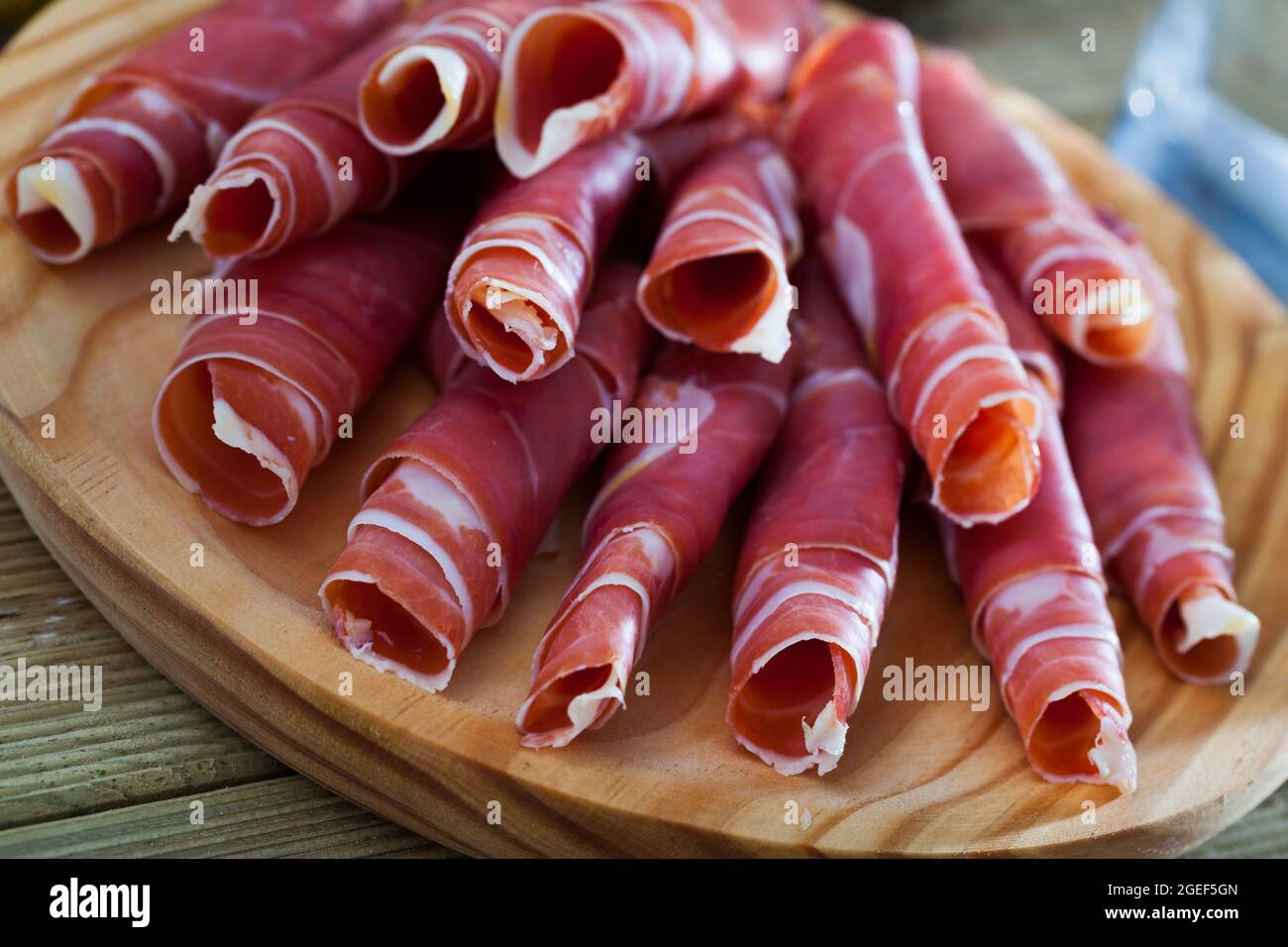 Rolled up slices of dry-cured ham Stock Photo - Alamy