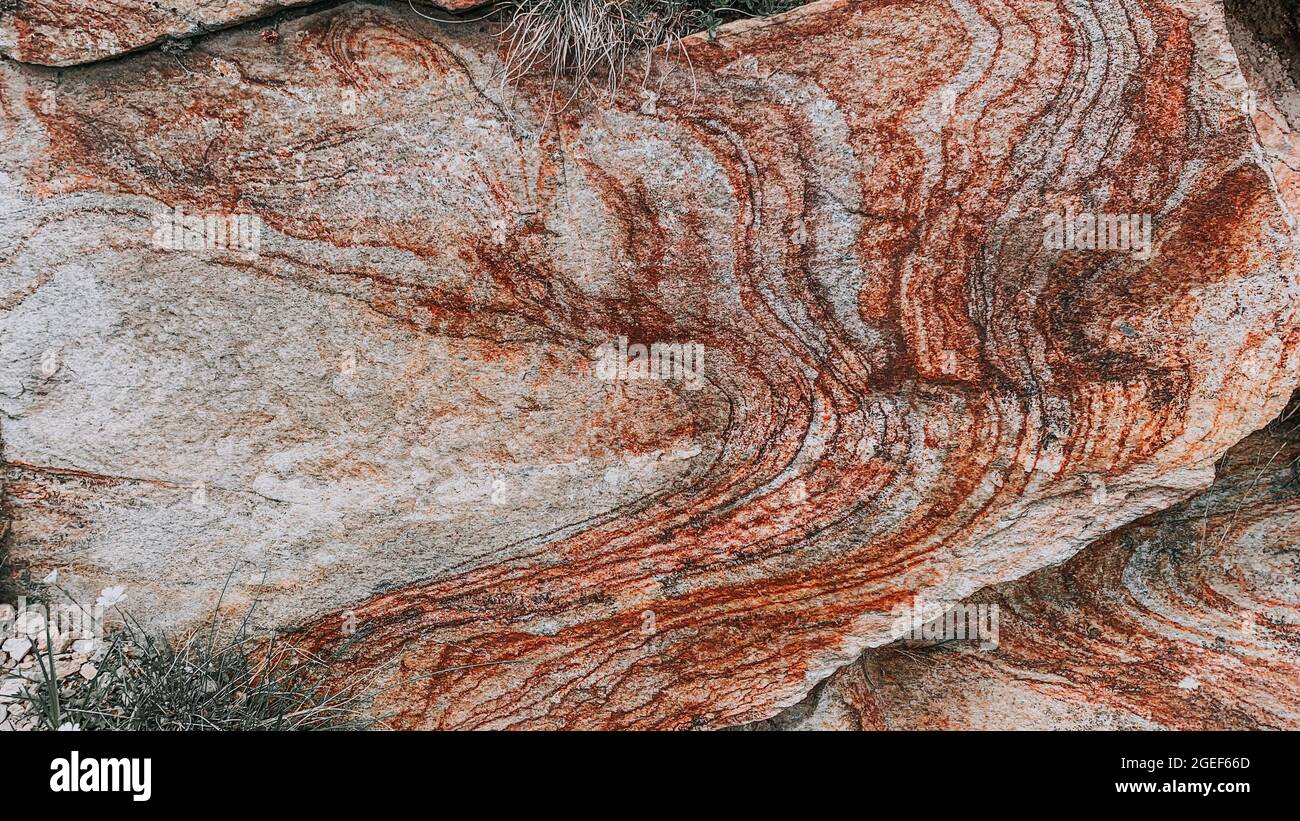 Closeup of geologic rock surface with red wavy pattern Stock Photo - Alamy