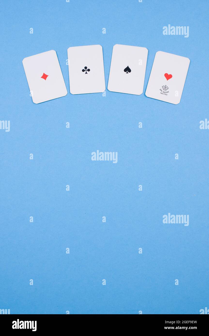 Vertical shot of four playing cards isolated on a blue background Stock ...