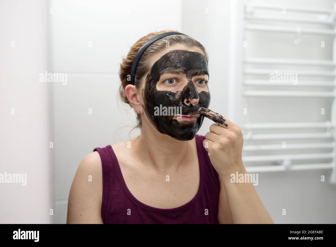 Spanish Caucasian woman with a charcoal face mask on her, in her ...