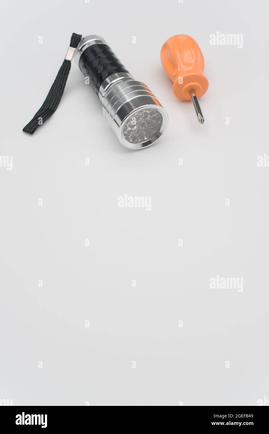 Vertical shot of a screwdriver with an orange handle and a small ...