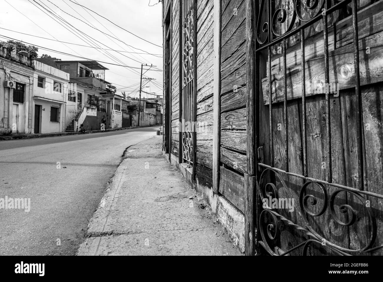 Grayscale shot of a narrow road surrounded by old buildings in the ...