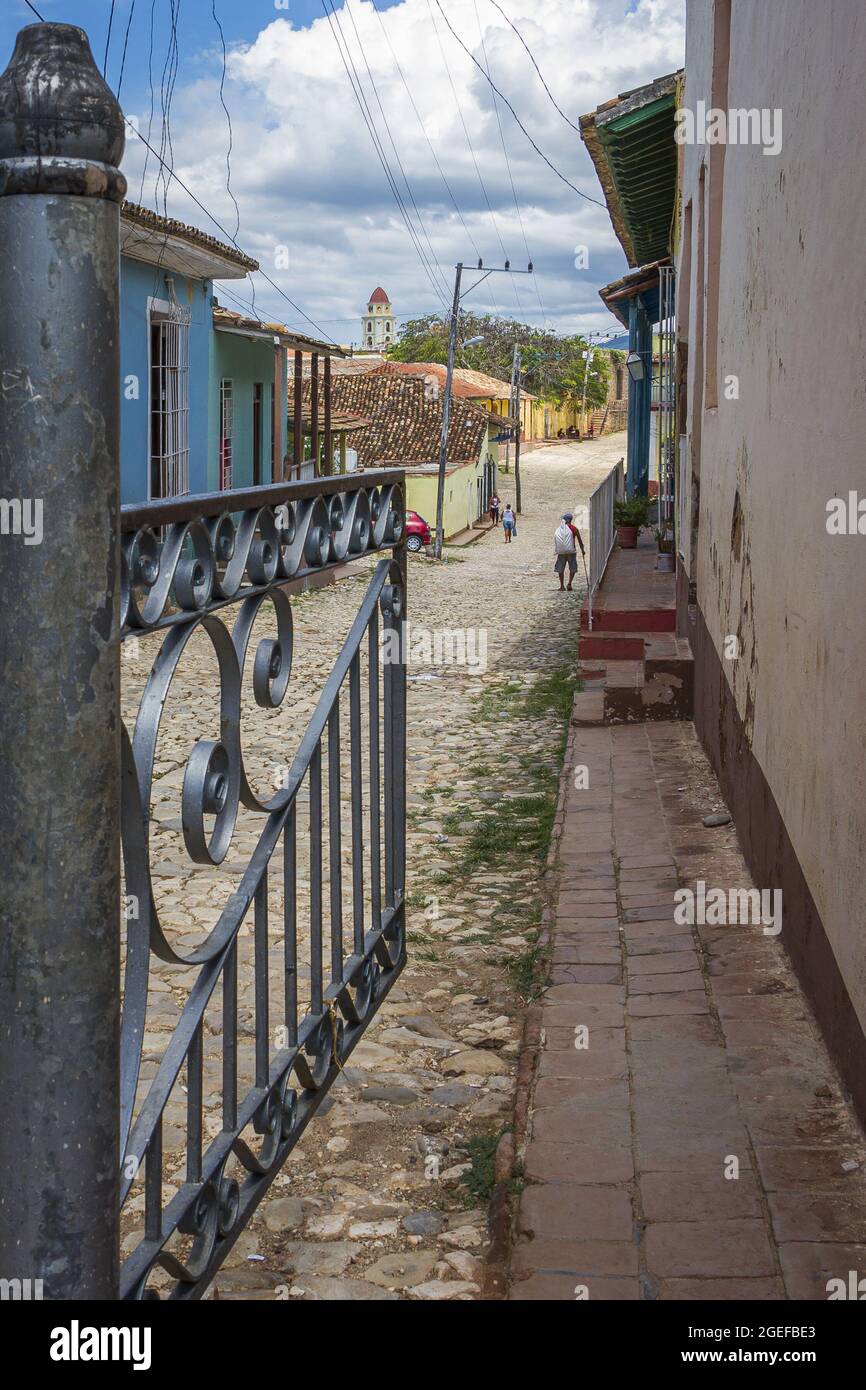 Vertical shot of an alley of old buildings under a blue cloudy sky ...