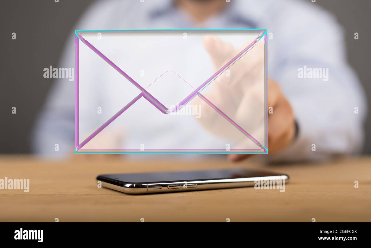 Businessman clicking on a large email icon over a phone-marketing ...