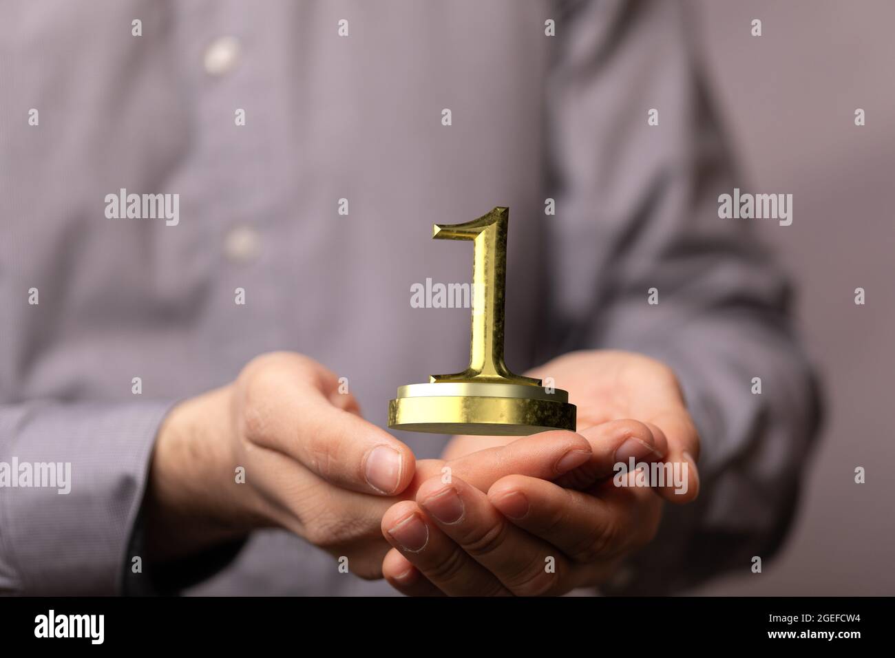 Hand holding a 3D decorative 1st place trophy sign Stock Photo - Alamy