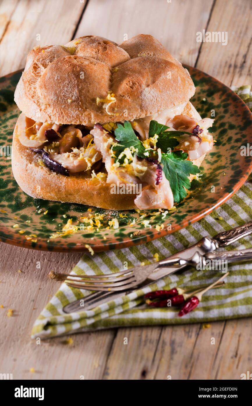 Street food, presentation of a round sandwich filled with boiled and ...