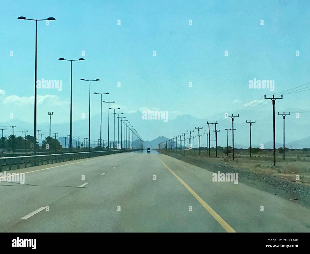 Empty road with only one car driving away Stock Photo - Alamy