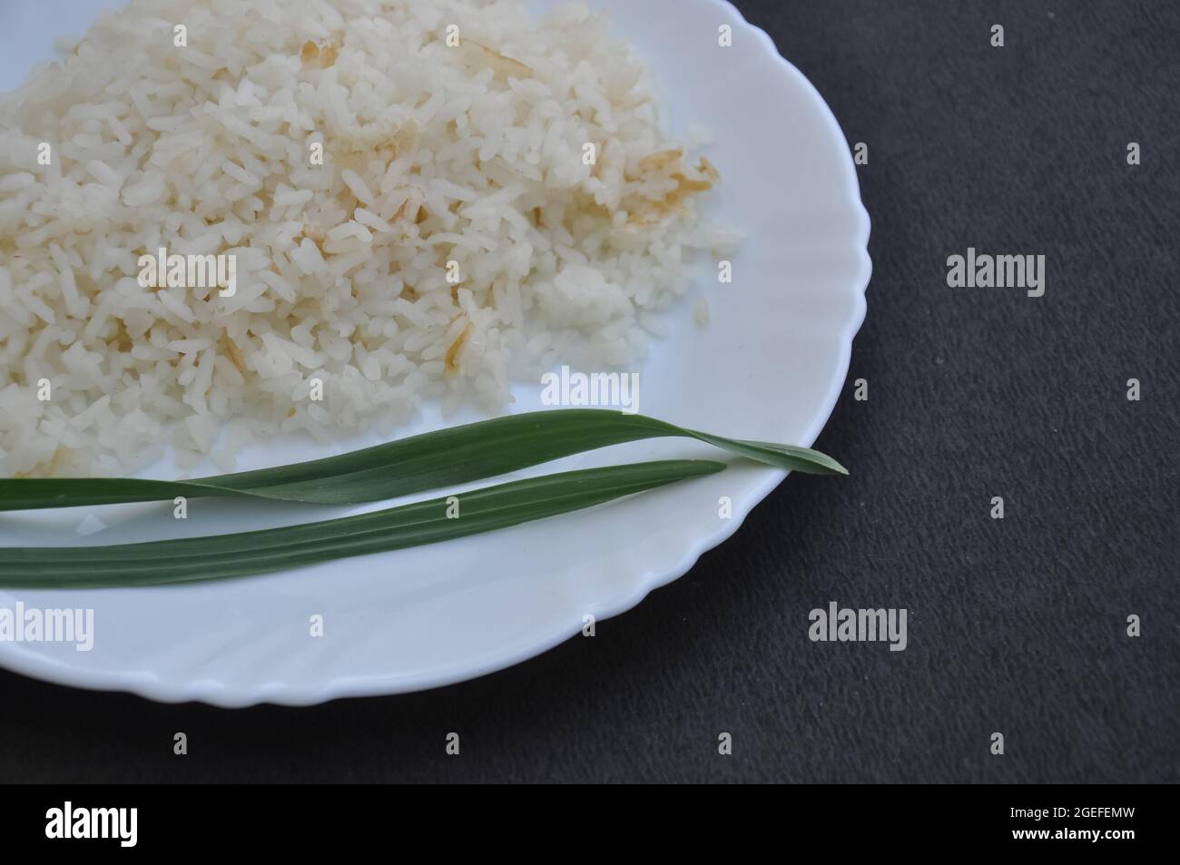 Overhead view of rice in white plate isolated over black background ...