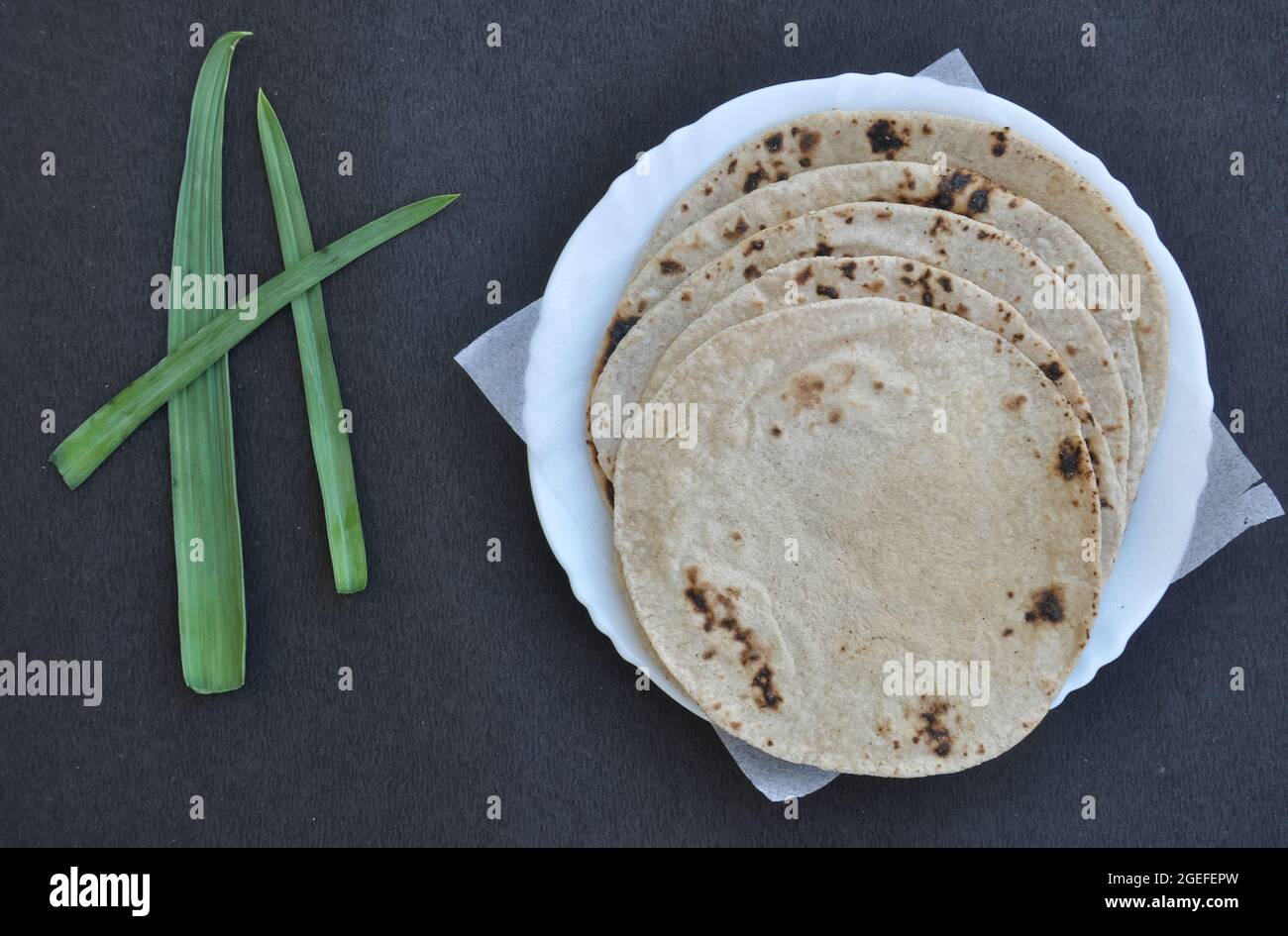 Top view of roti (chapati) on white plate over black background Stock ...