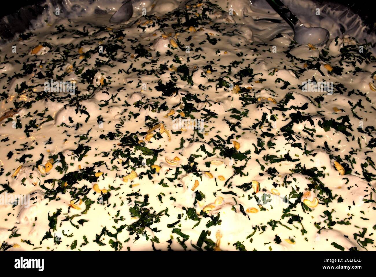 Dahibada is decorated with cashew and coriander leaves and placed in a ...