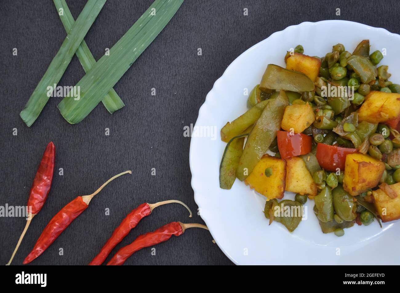 Flat lay of matar paneer mix veg recipe (Indian food) and red chillies ...