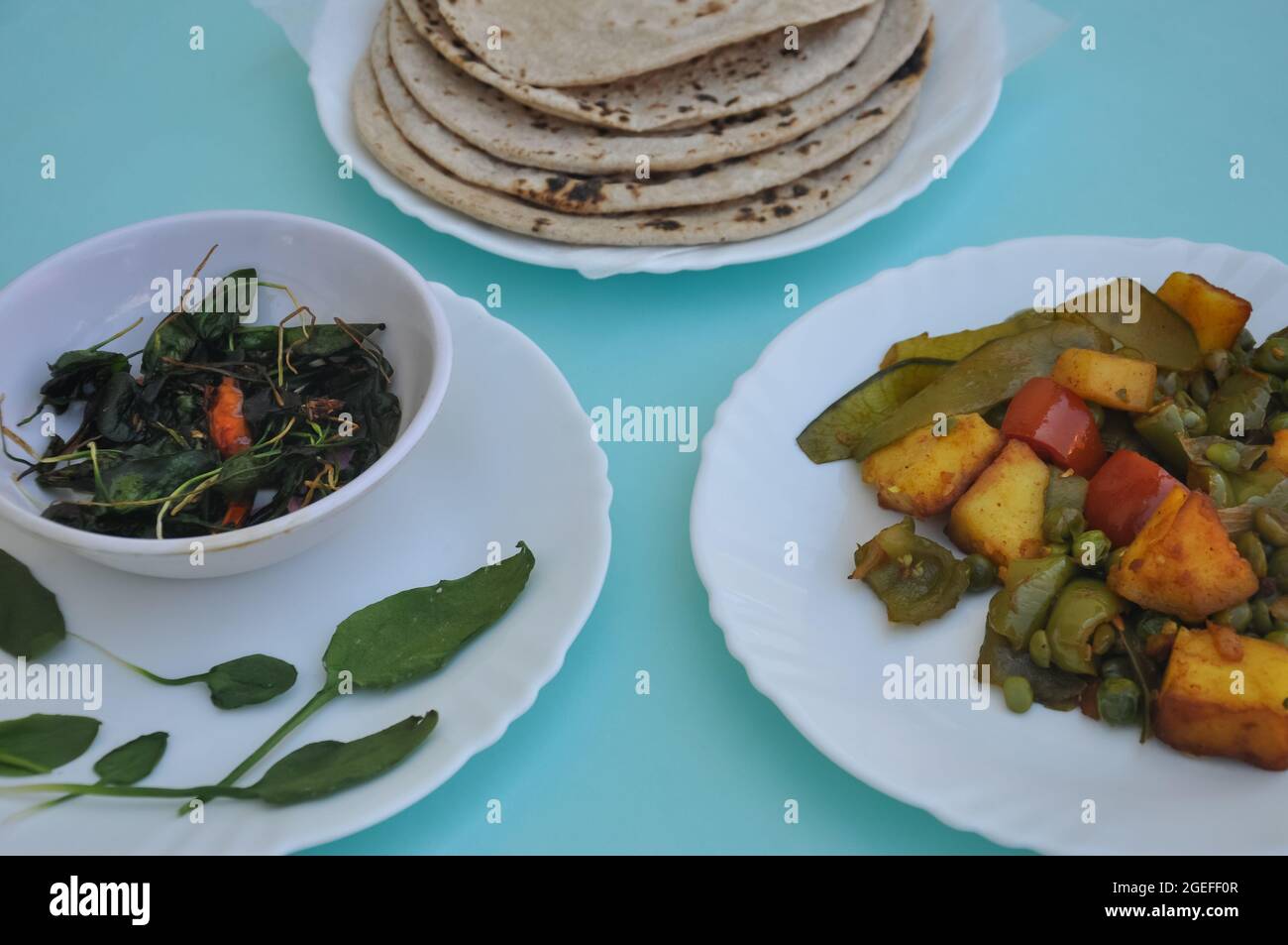 North Indian Food - Matar paneer mix veg, saag and roti on white plate ...