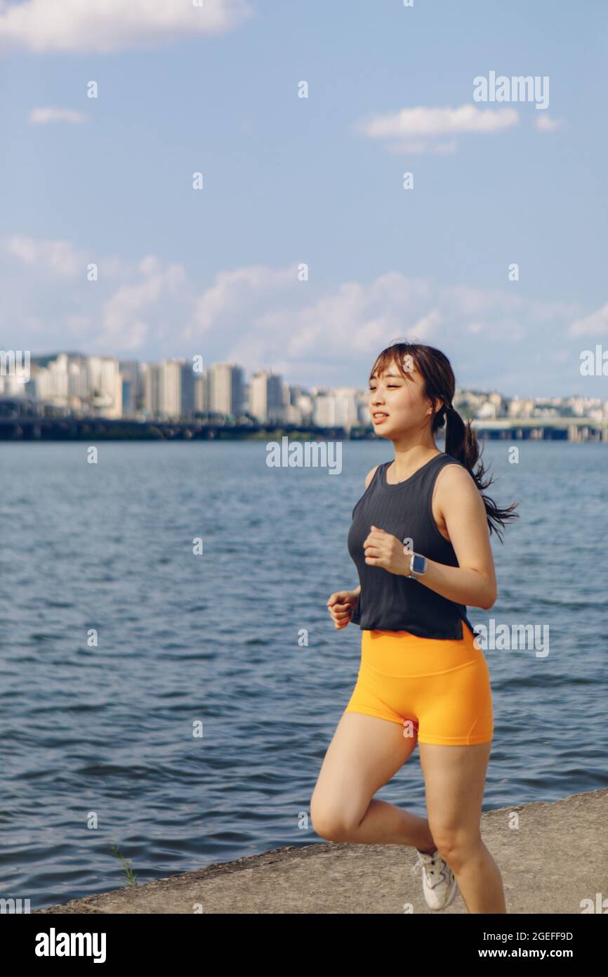 Young East Asian female doing her early morning jogging and workout ...