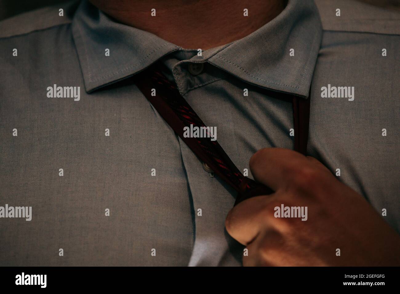 Closeup of a man unlooses a tie Stock Photo - Alamy