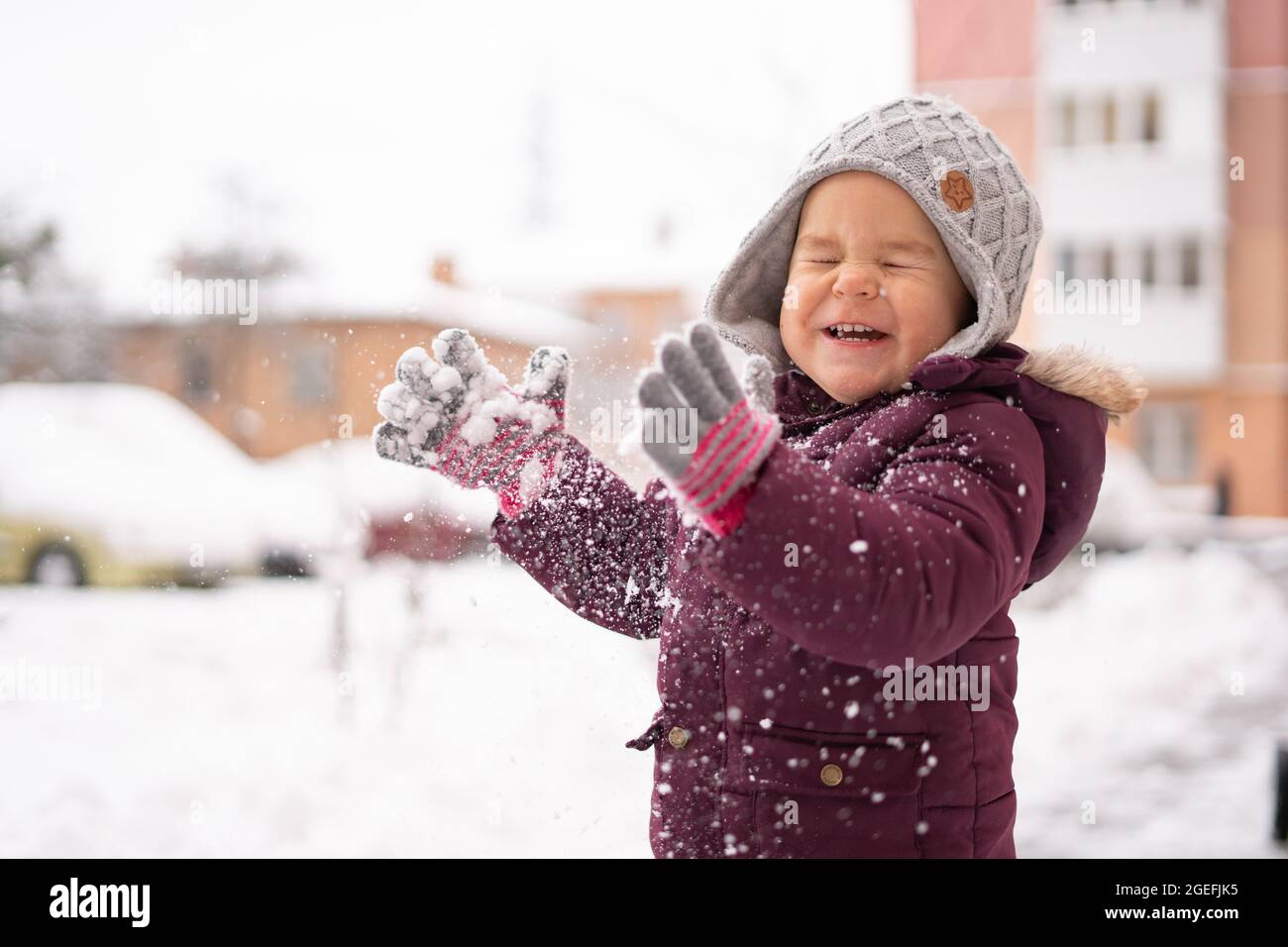 Toddler portrait with first snow. Happy child on a winter snowy day ...