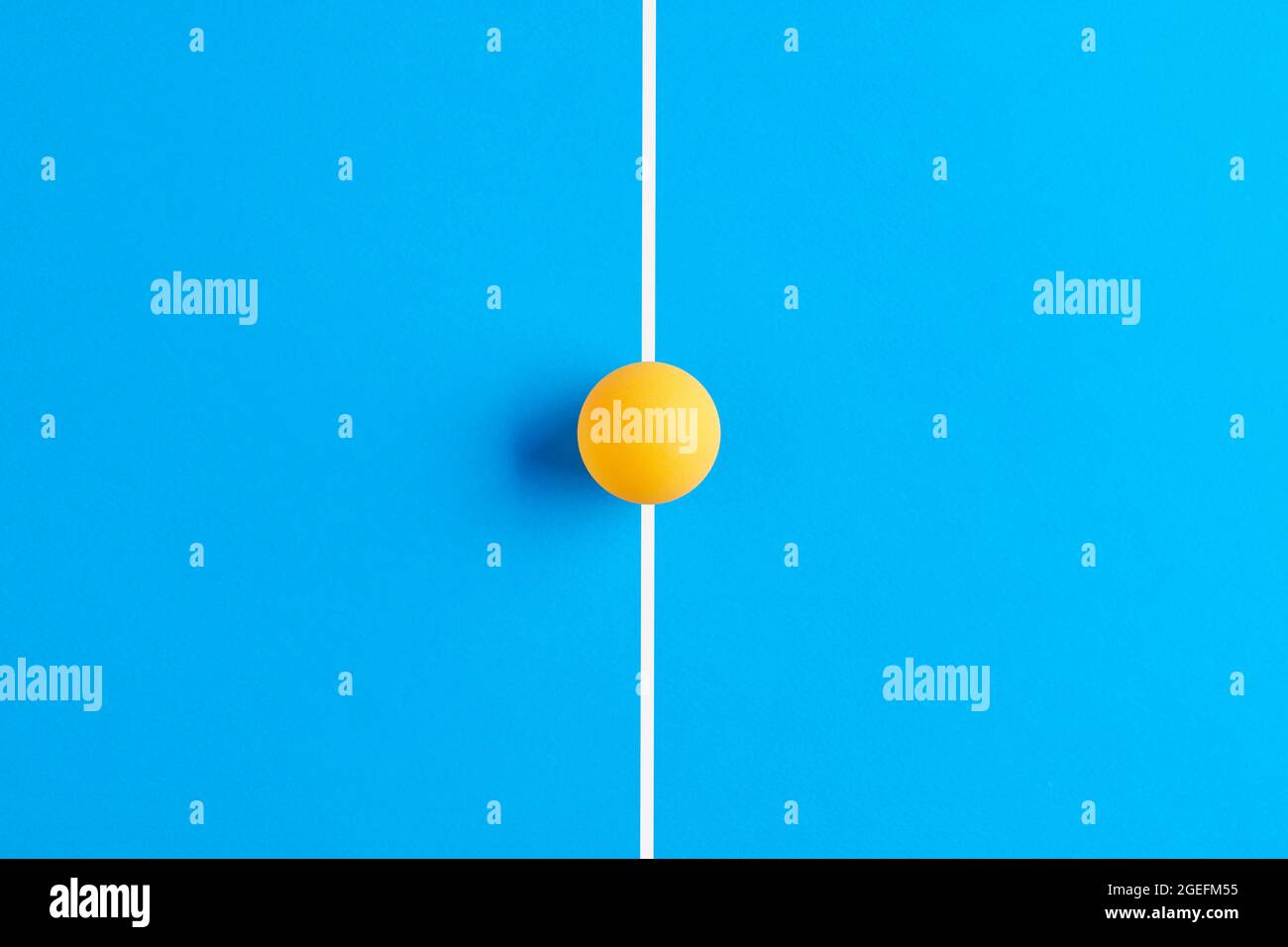 Yellow table tennis ball on the line of a blue ping pong table Stock ...