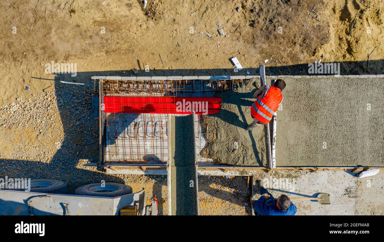 Above top view, overhead on construction workers are leveling fresh ...