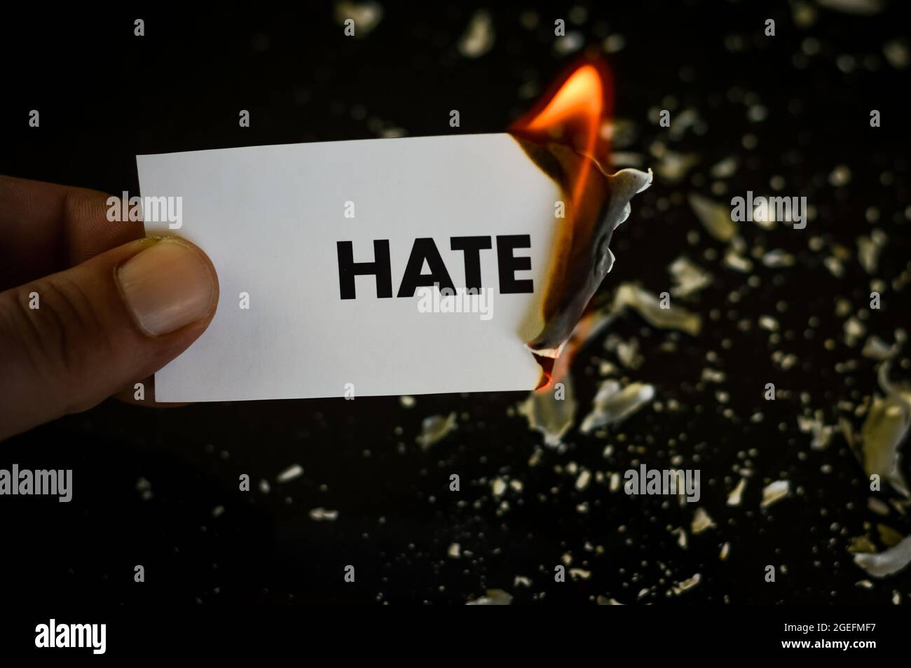 burning hate, human hand holding the word hate written on a paper ...