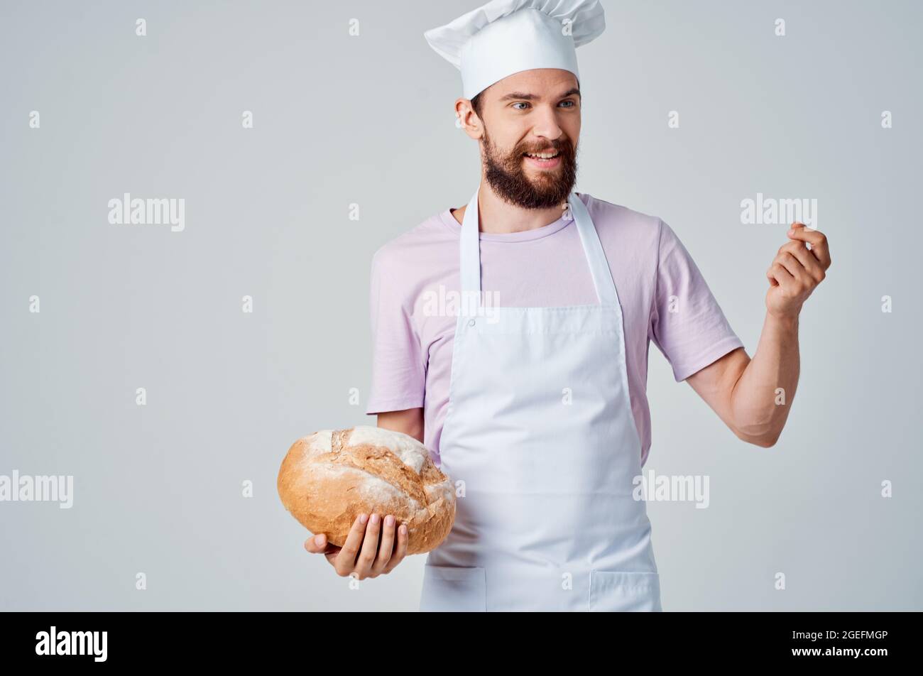 emotional Baker in a White apron with bread in his hands Professional Stock Photo - Alamy