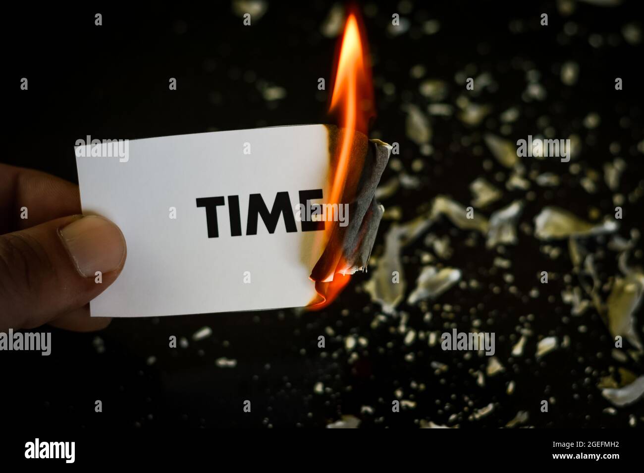 burning time, human hand holding the word time written on a paper ...