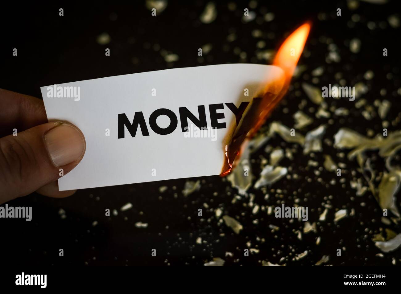 burning money, human hand holding the word money written on a paper ...