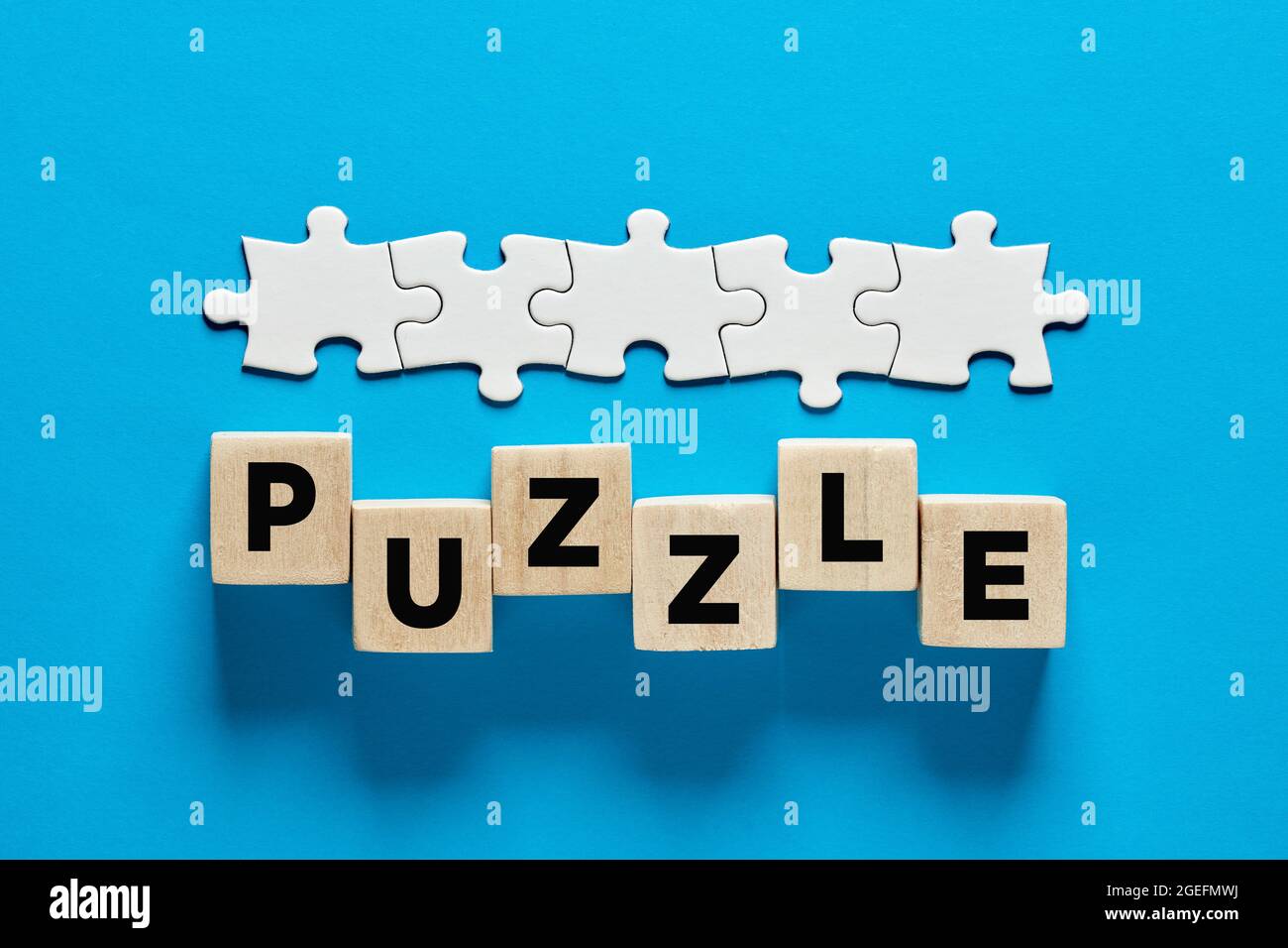 The word puzzle on wooden cubes with a connected line of jigsaw puzzle ...