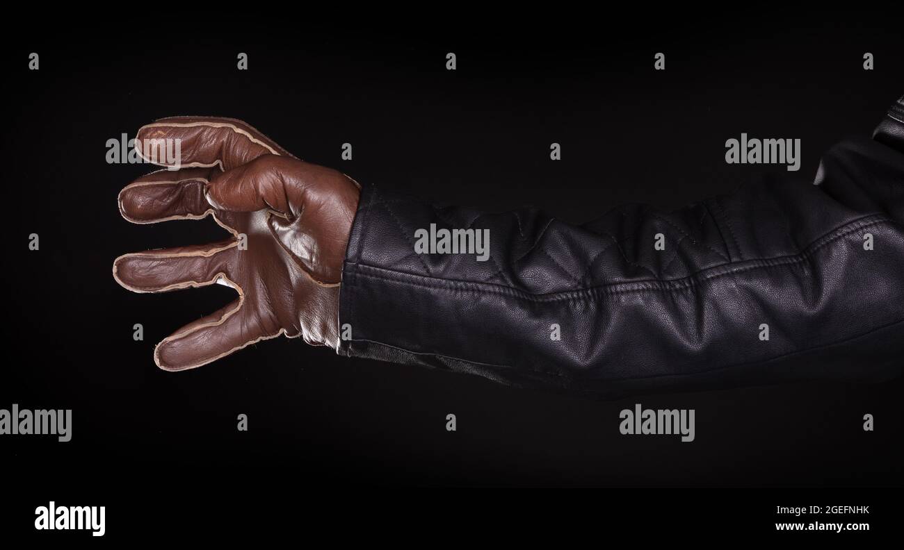 Arm with black leather jacket and brown glove, isolated on black Stock ...