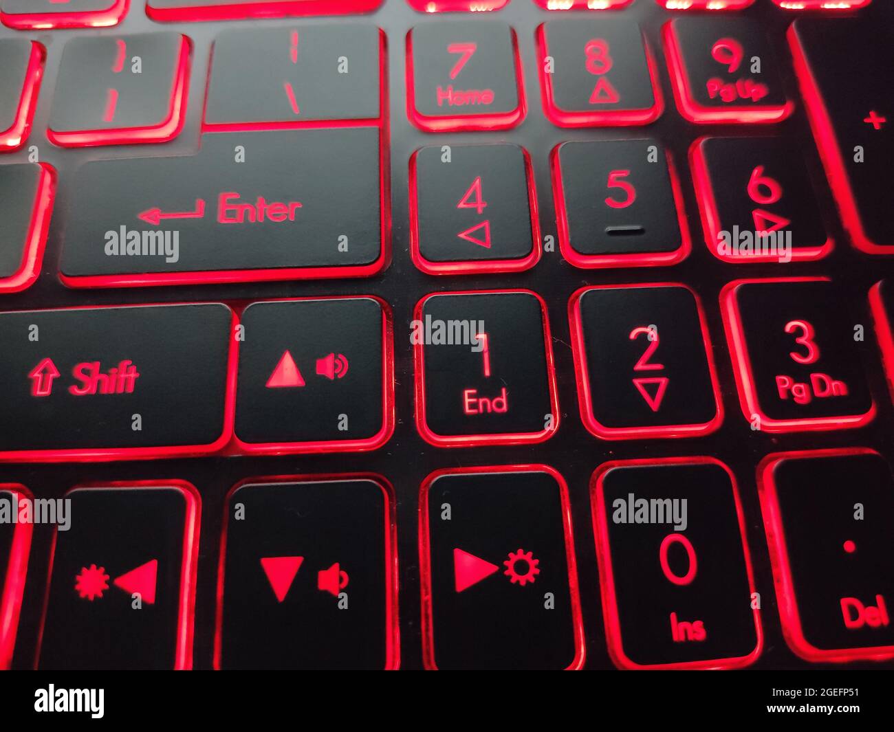 Closeup shot of an English language laptop keyboard with glowing red ...
