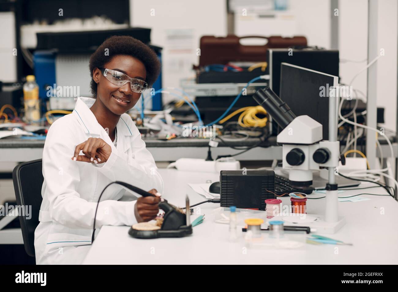 Scientist african american woman in laboratory with soldering iron ...