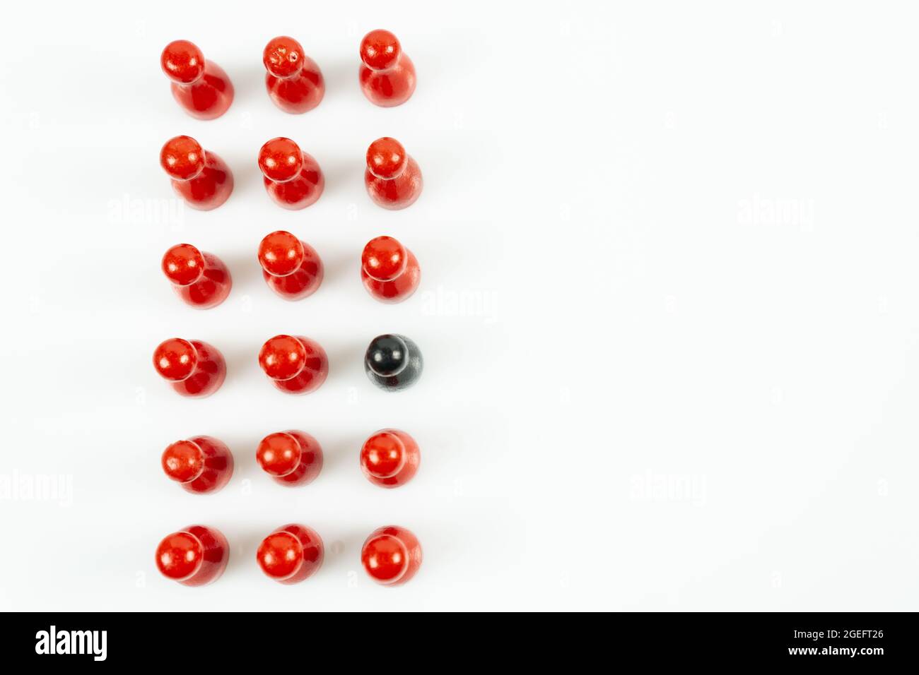 Overhead shot of a single black pawn with red pawns isolated on white ...