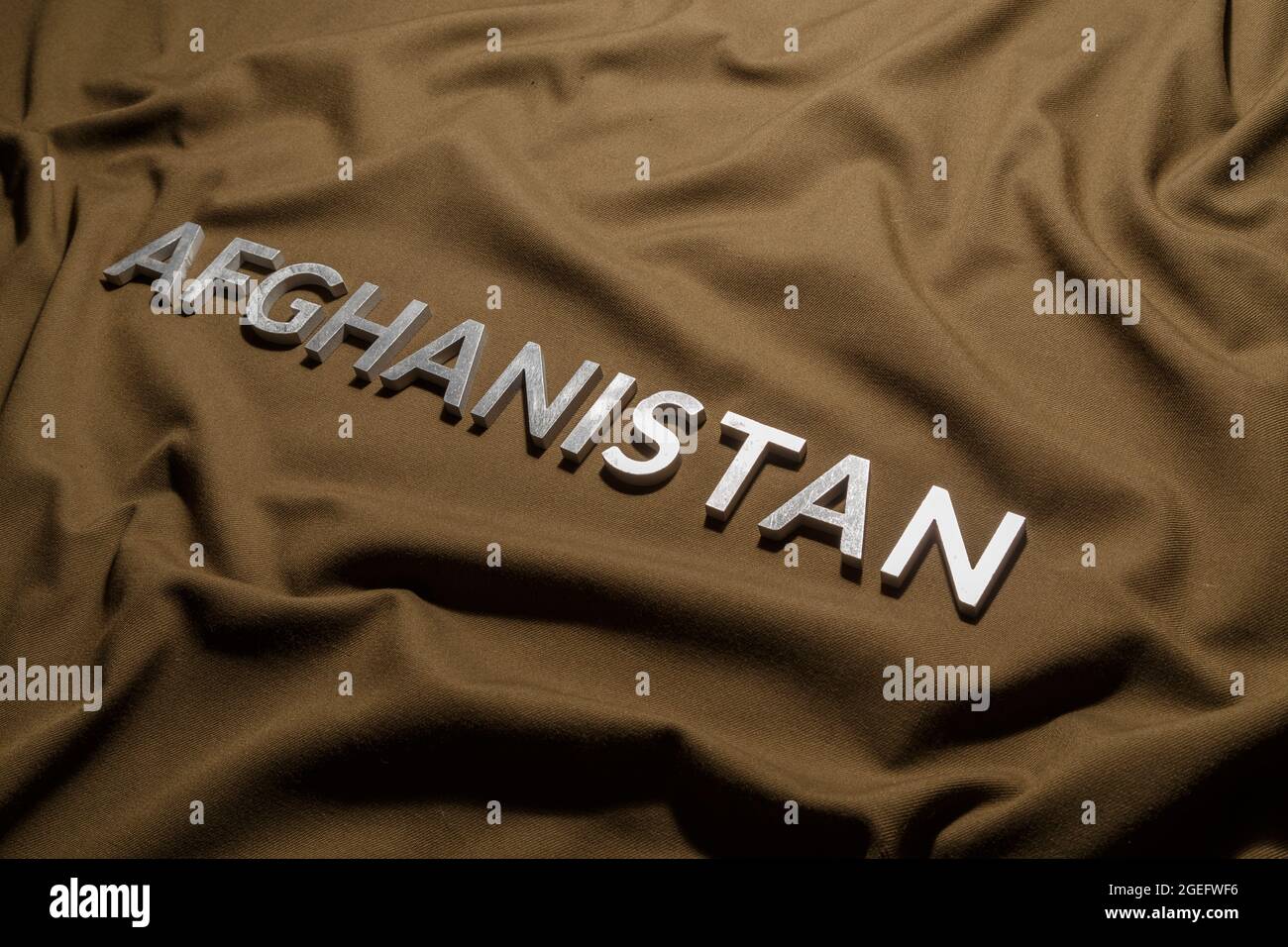 the word afghanistan laid with silver metal letters on tan khaki canvas ...