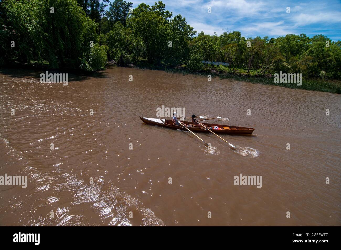 TIGRE, ARGENTINA - Nov 12, 2010: A pair of women rowing in the brown ...