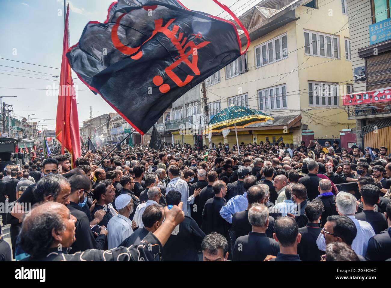 A Kashmiri Shia Muslim man waves a religious flag during the Ashura ...