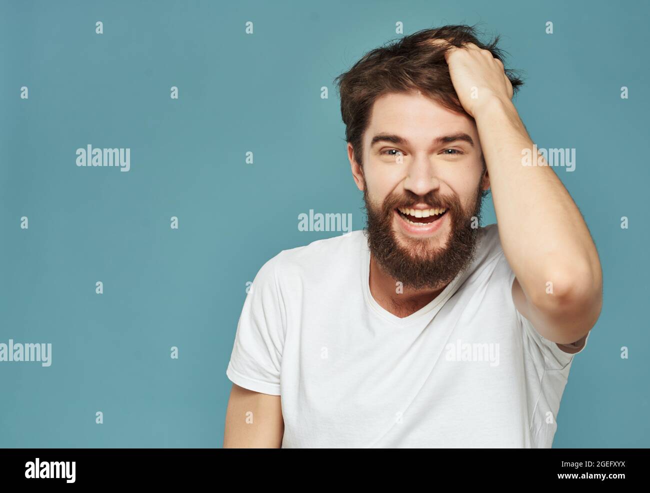 emotional man in a white t-shirt hand gestures anger blue background ...