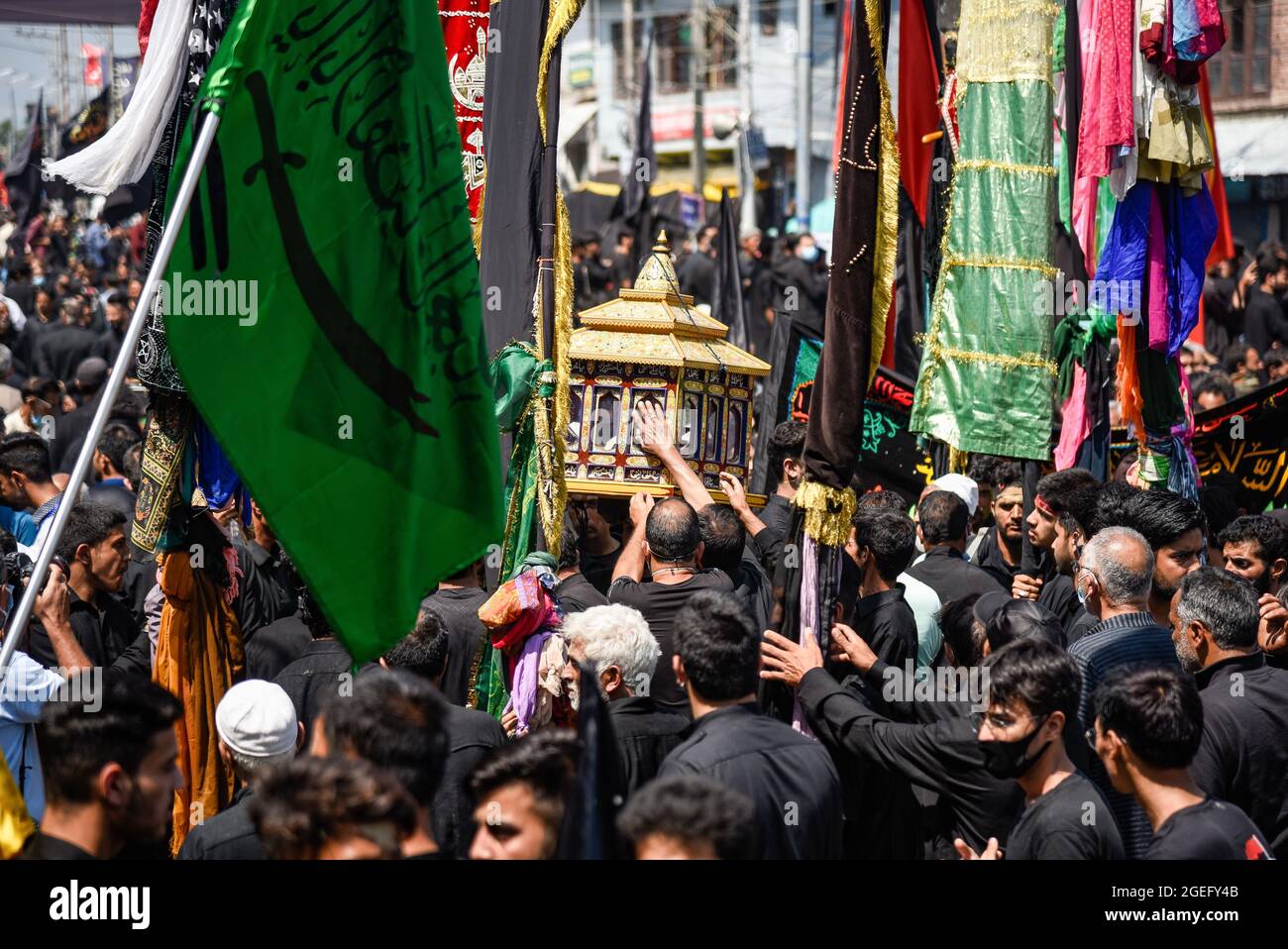 Kashmiri Shia Muslims touch a glass case containing the Holy Qur'an ...