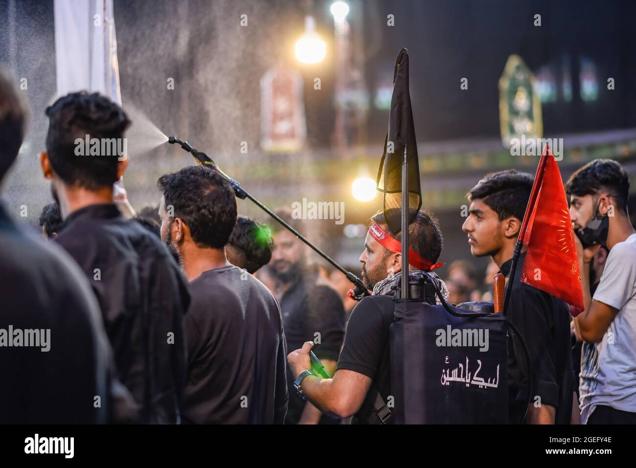 A Kashmiri Shia Muslim man sprays rose water among the mourners during ...