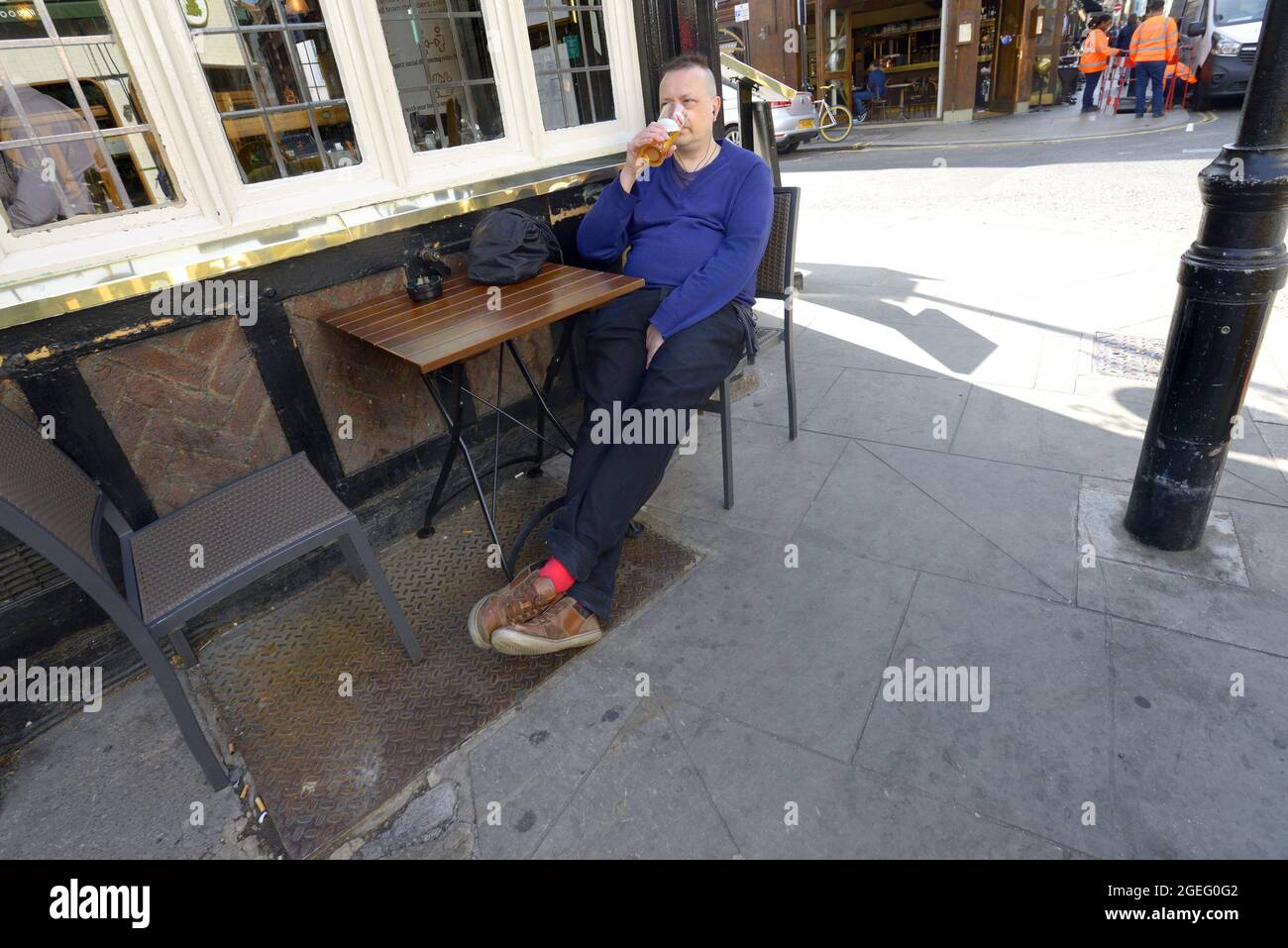 London, England, UK. Man having a drink outside a pub on his own Stock ...