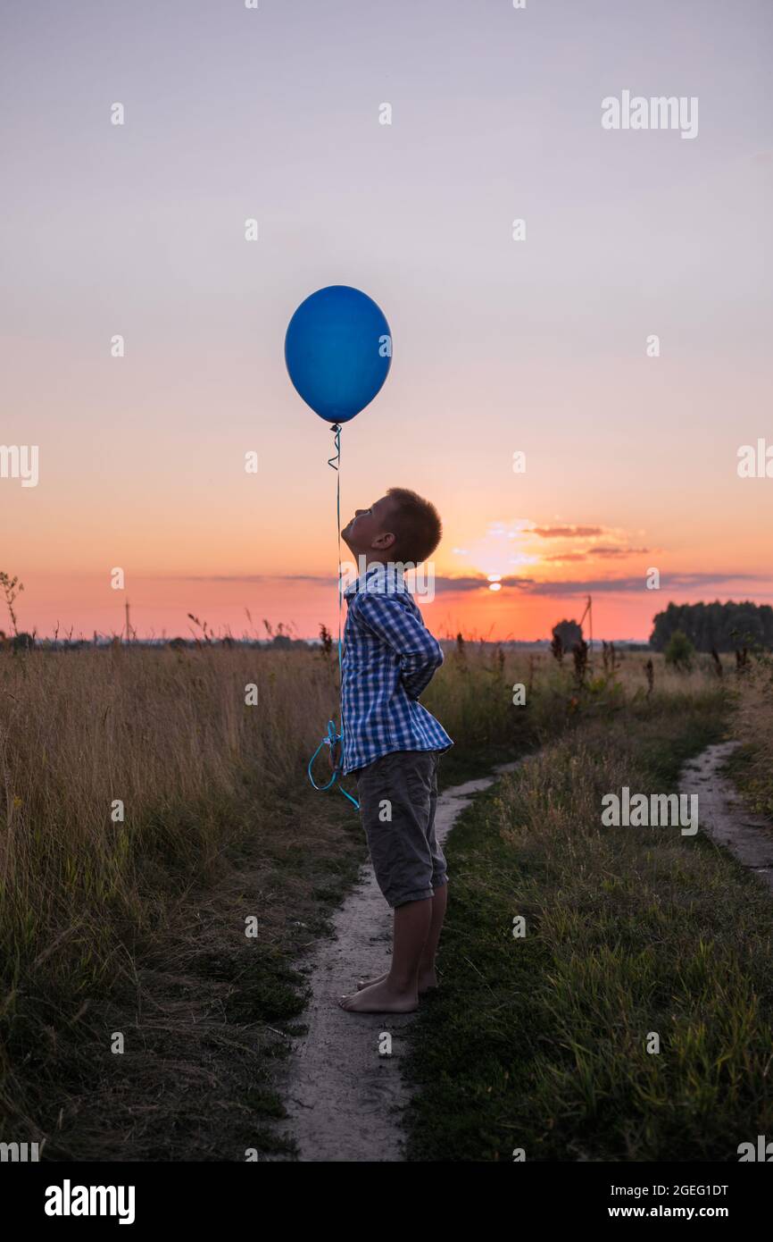 Happy Boy makes his wishes and dreams Outdoors with Helium Balloons ...