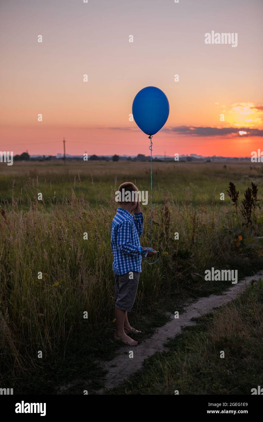 Happy Boy makes his wishes and dreams Outdoors with Helium Balloons ...