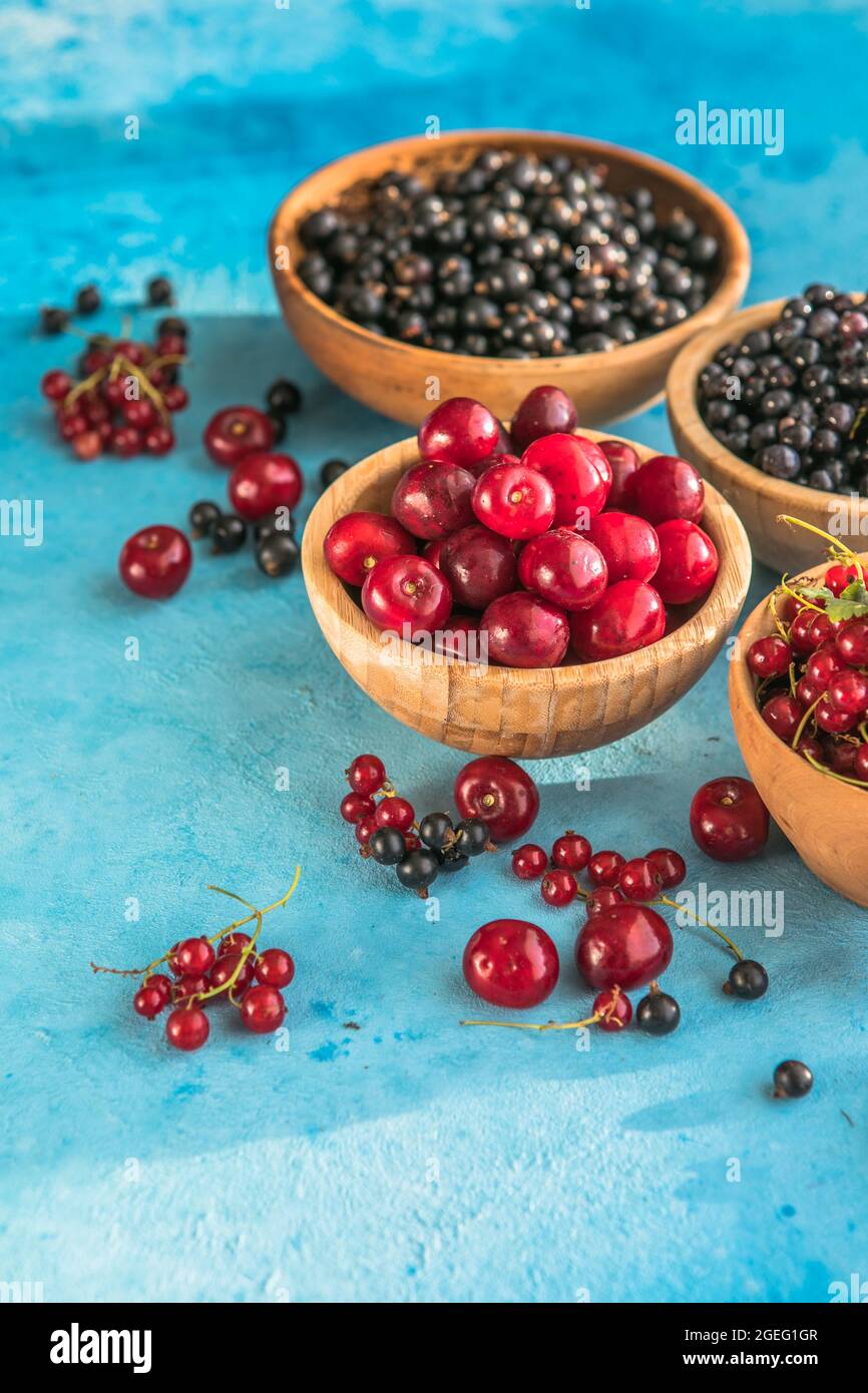 Fresh organic summer berries mix on blue concrete background ...