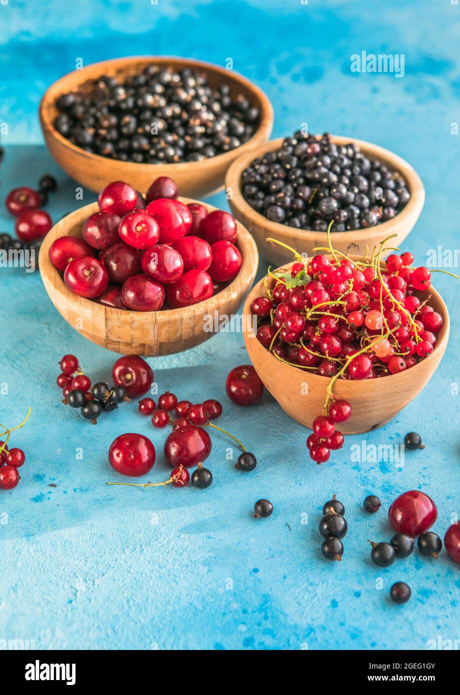 Fresh organic summer berries mix on blue concrete background ...