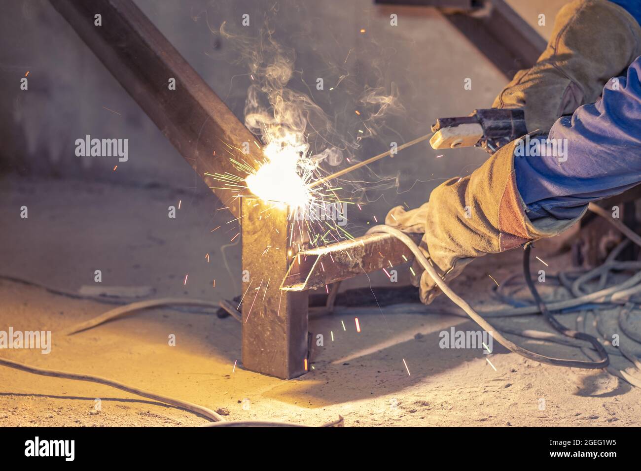 Man welder assembles a metal staircase structure in a residential ...