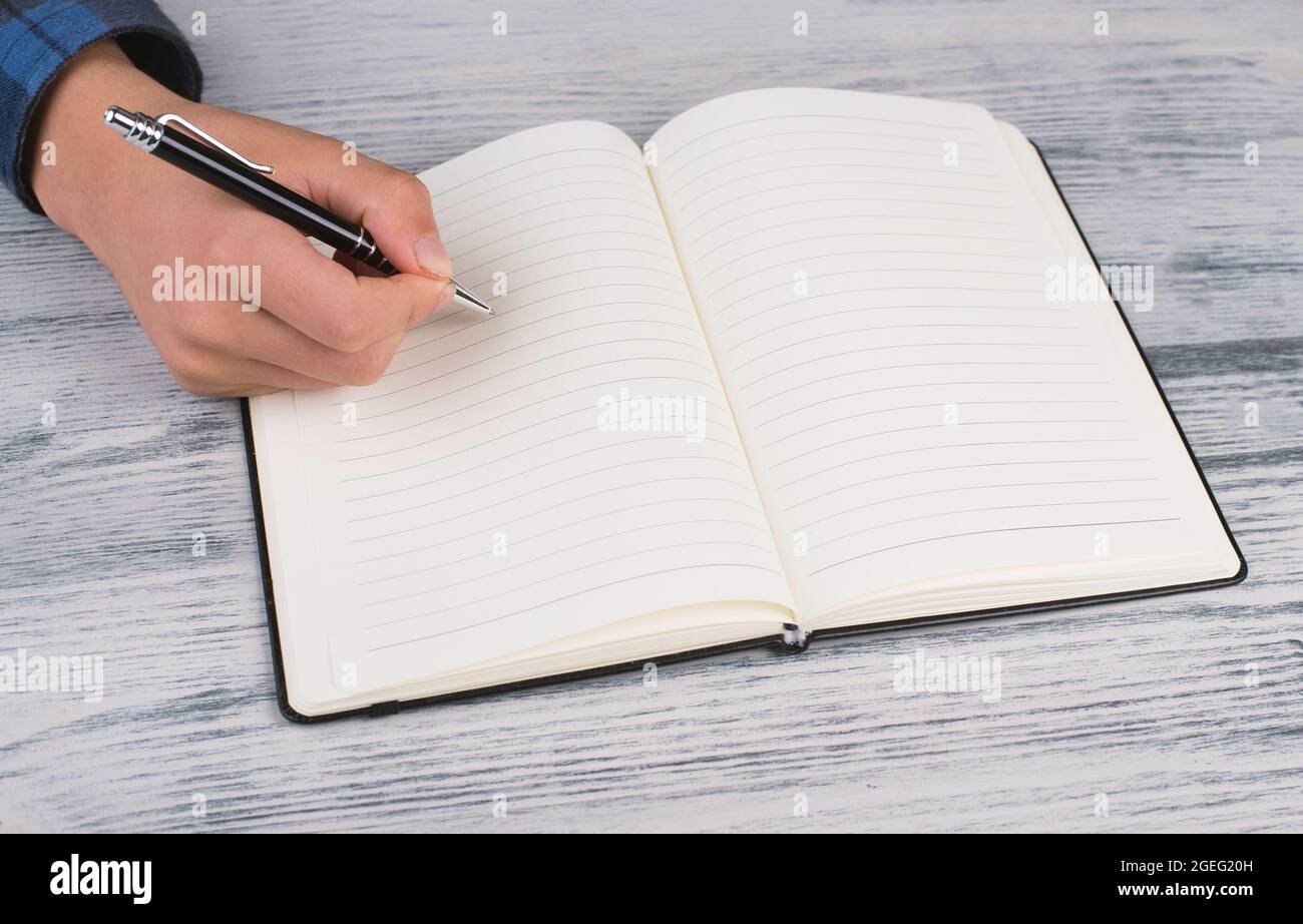 Writing into a book, empty copy space for text, hand with a pen Stock ...
