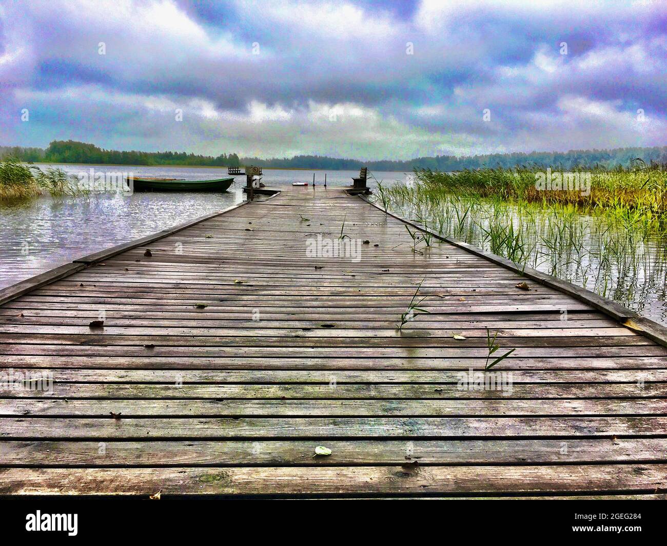 Floating boardwalk and a boat in a lake under a cloudy sky Stock Photo ...