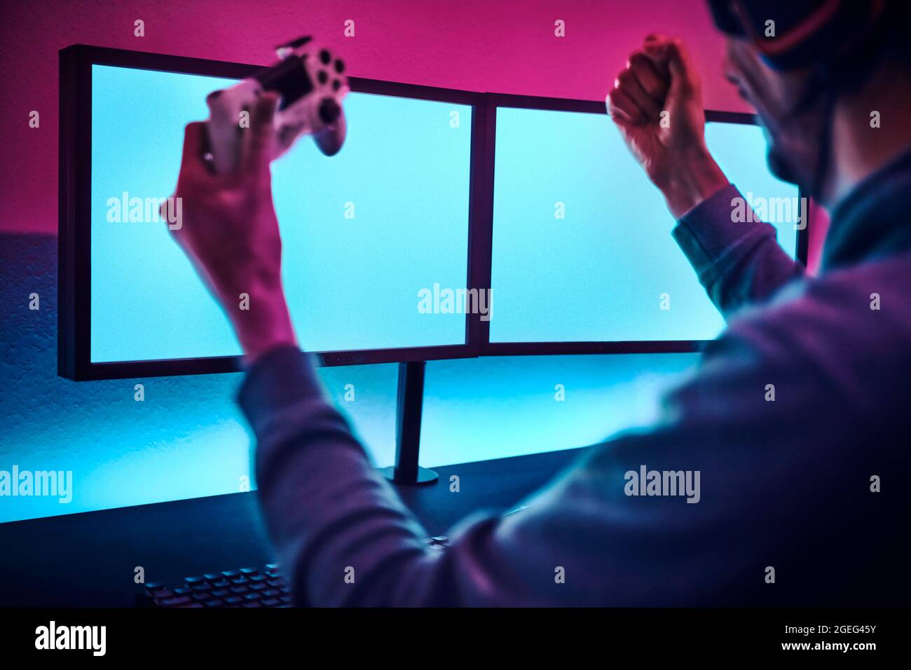 Man holding gamepad gesturing success in playing by rising hands. Blank ...