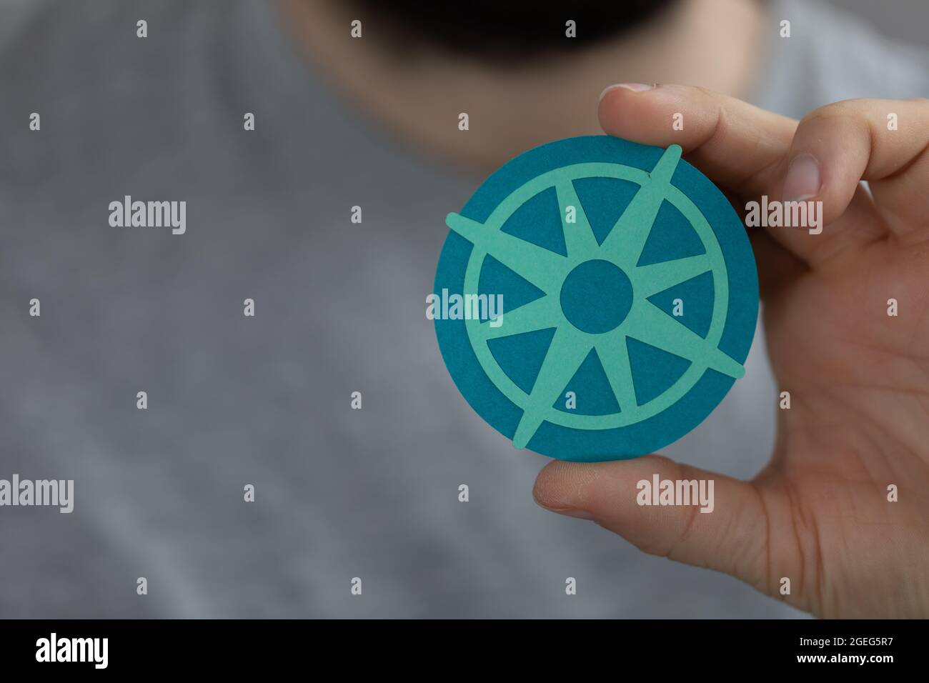 Male's hand holding a travel compass made from paper Stock Photo - Alamy